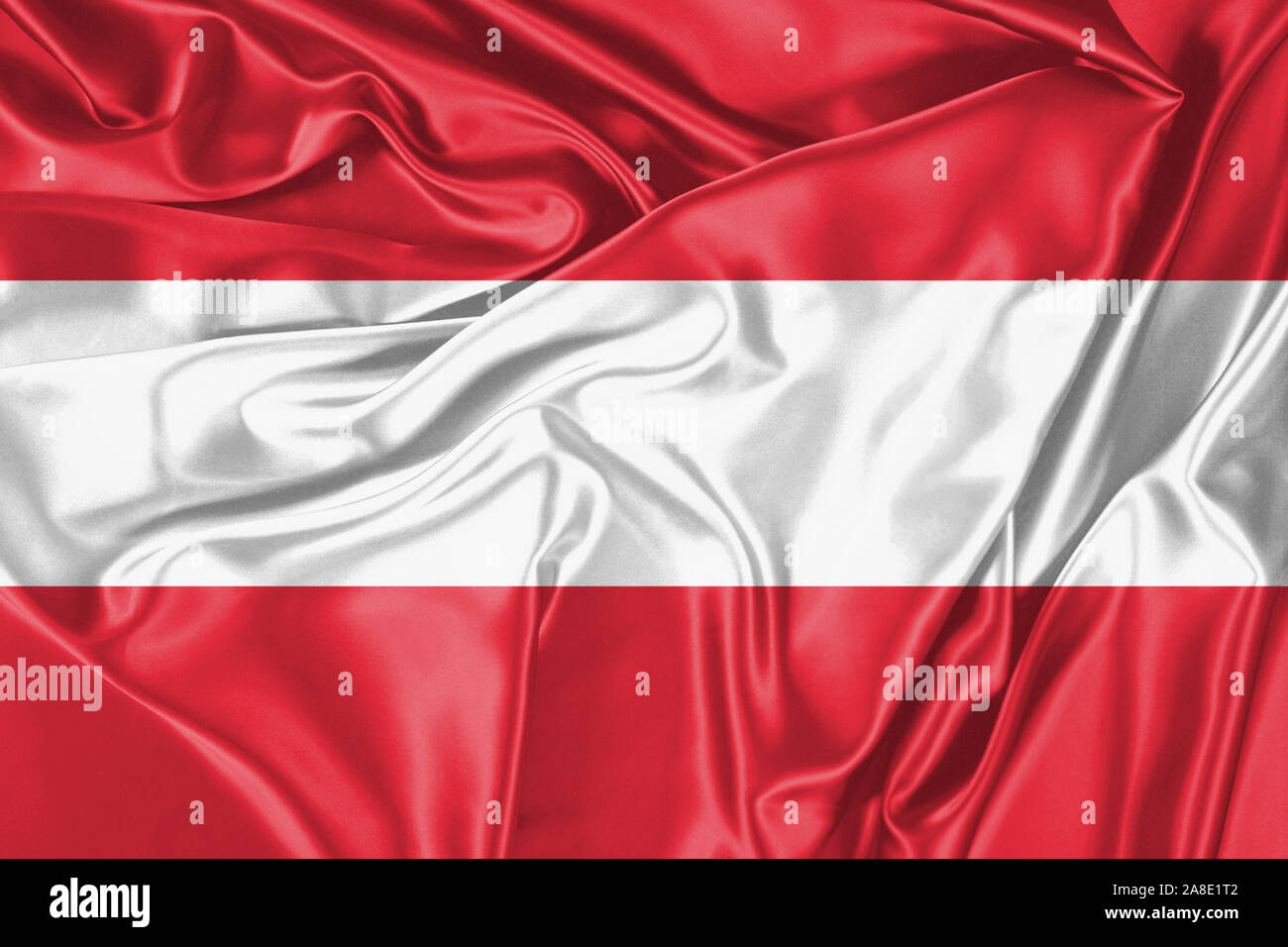 Shiny crippled Austrian flag is laying on a surface. Realistic ...