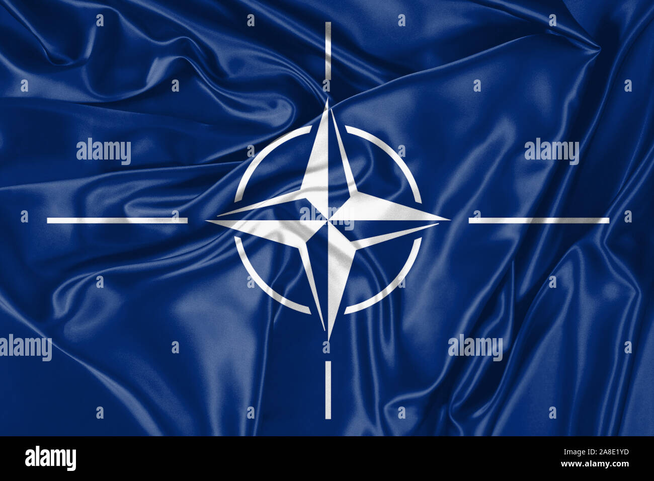 Shiny crippled NATO flag is laying on a surface. Realistic reflections ...