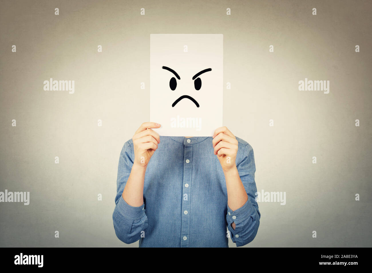 Teen boy covering face using a white paper sheet with angry sad ...