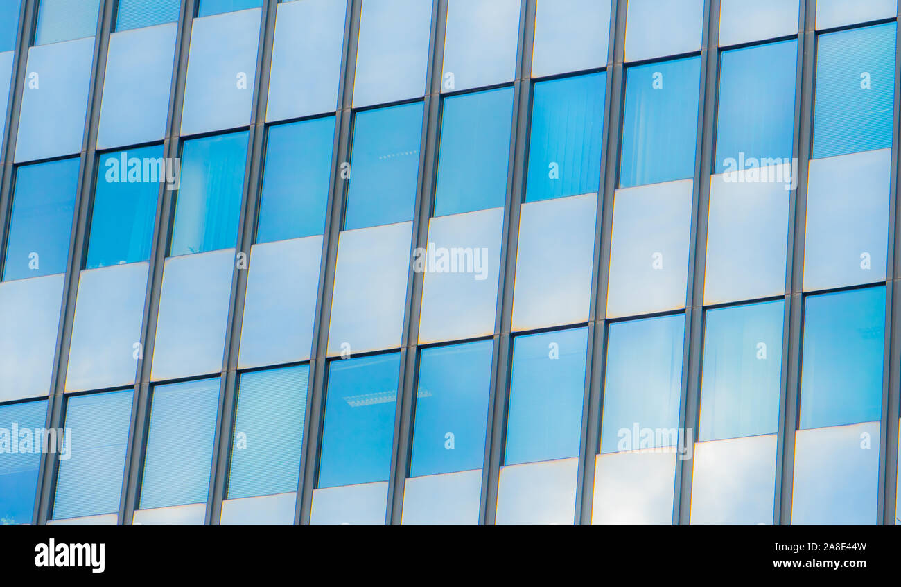 Glass facade of a modern office building with reflections in the ...