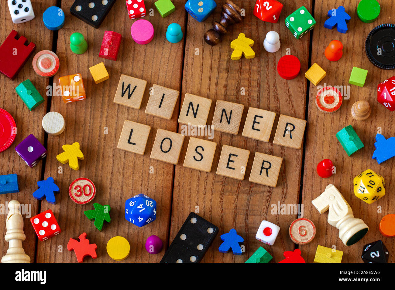 "Winner Loser" spelled out in wooden letter tiles. Surrounded by dice ...