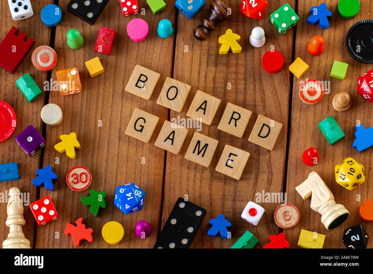 "Board Game" spelled out in wooden letter tiles. Surrounded by dice ...