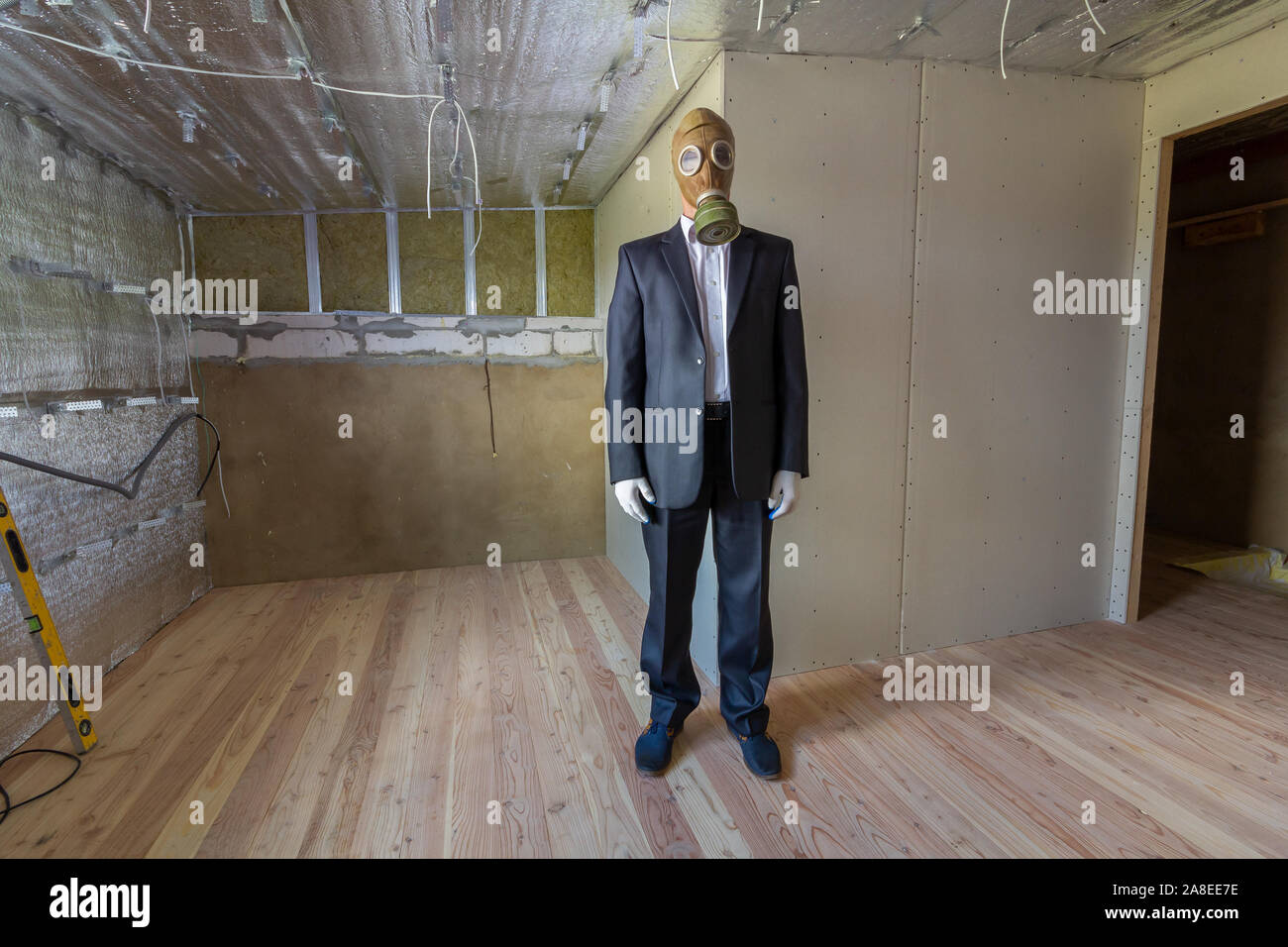 Strange man in businessman suit and gas protection mask inside a room ...