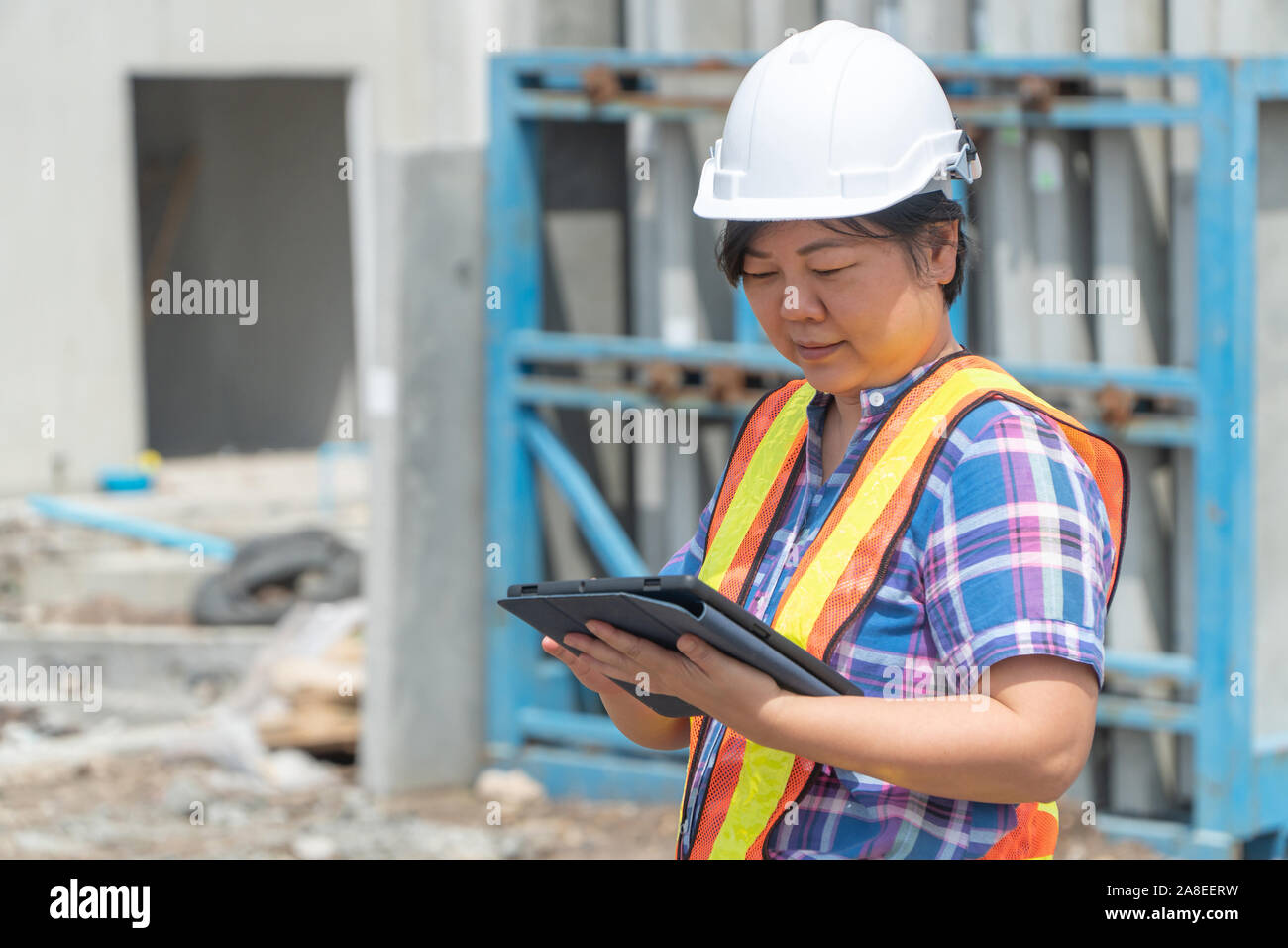 Asian women worker and engineer on building site using tablet for ...