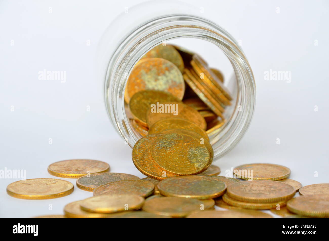 gold coin pour from glass bottle on white background Stock Photo - Alamy