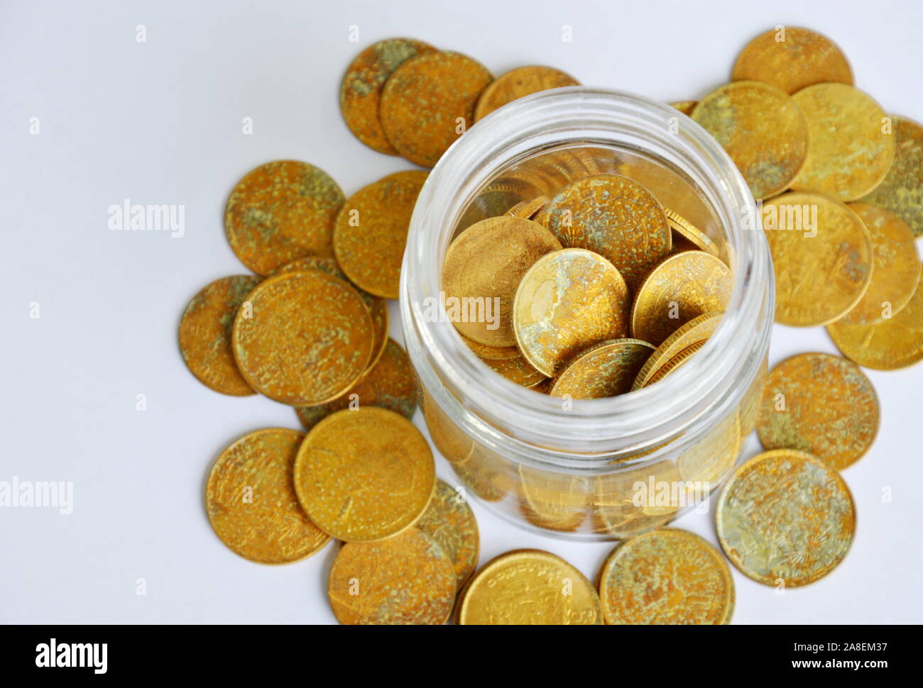 gold coin pour from glass bottle on white background Stock Photo - Alamy