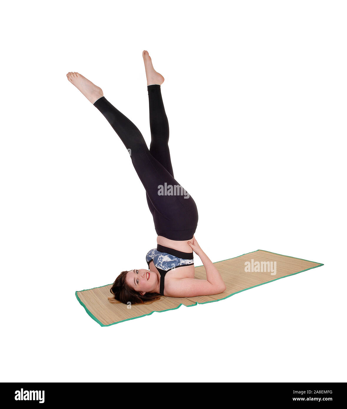 A beautiful young woman exercising on the floor her legs up in the air ...