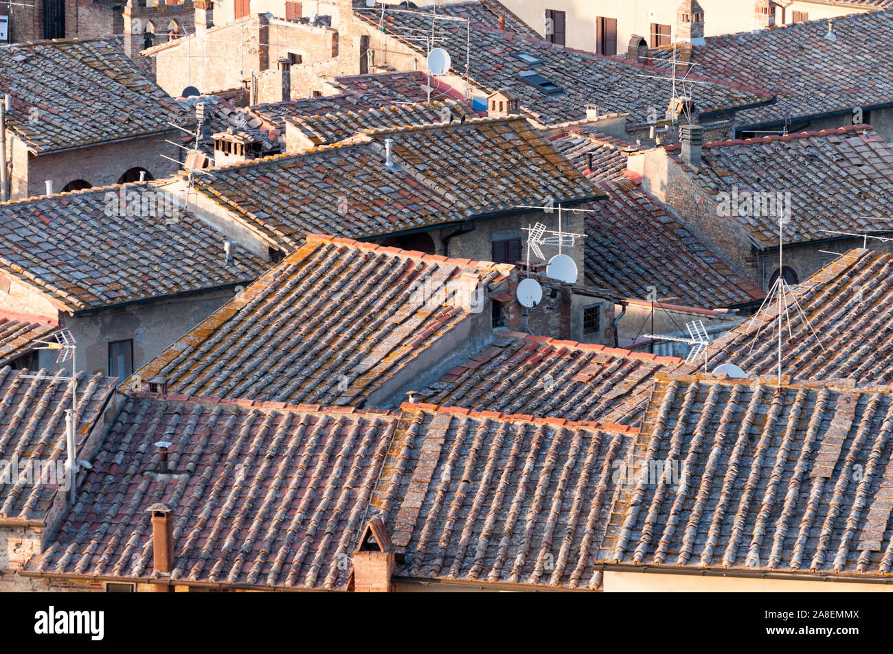 red tile roofs and antennas on traditional italian buildings in Tuscany ...