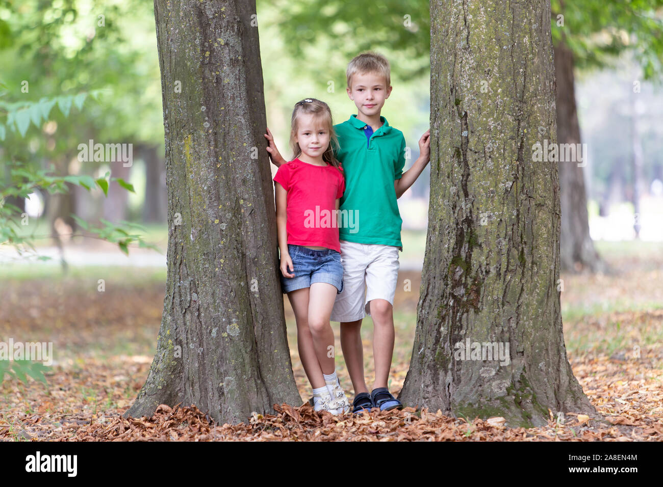 Portrait of two pretty cute children boy and girl standing near big ...