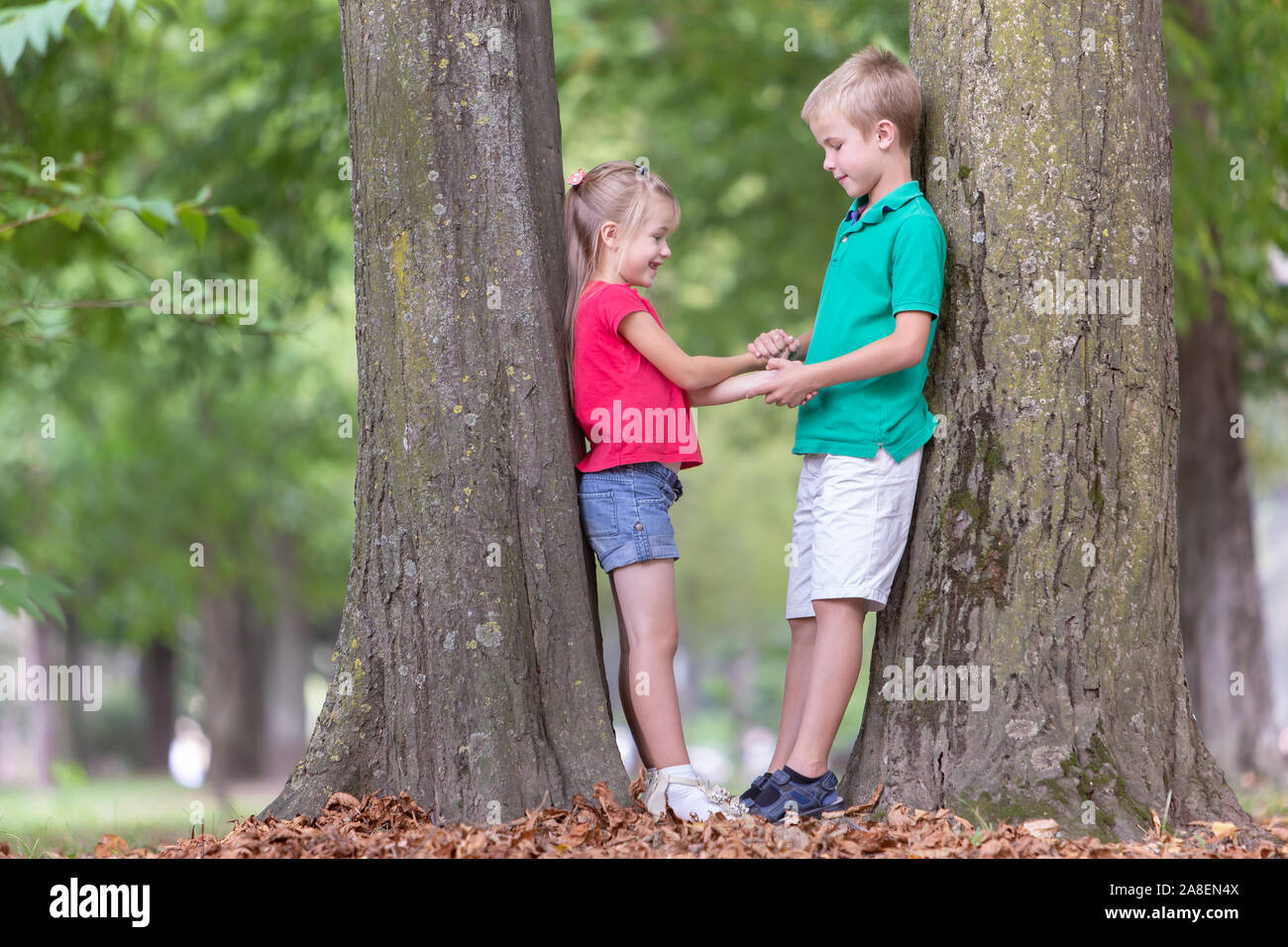 Portrait of two pretty cute children boy and girl standing near big ...