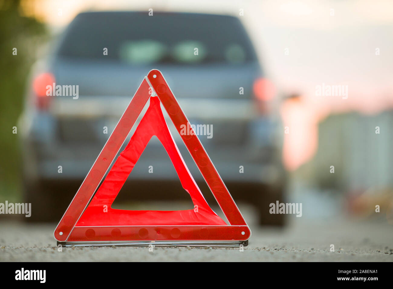 Red emergency triangle stop sign and broken car on a city street Stock ...