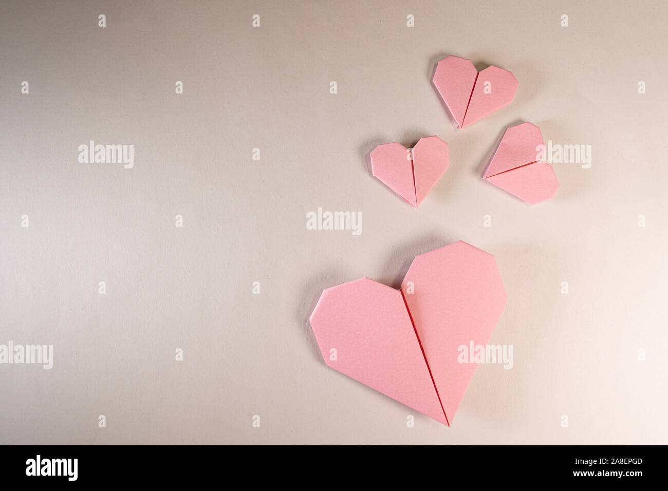 Pink origami hearts on a paper background Stock Photo - Alamy