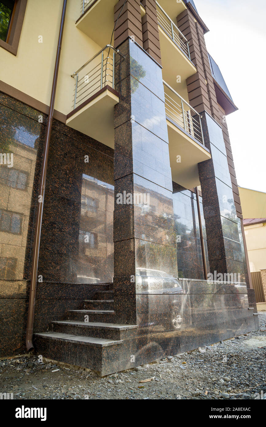 Part of a building facade with the surface of granite wall. Natural ...