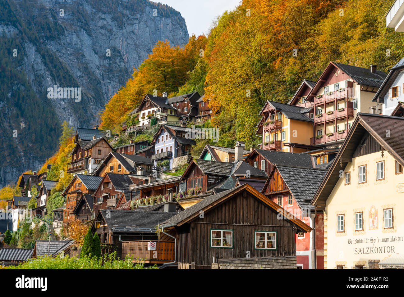 Hillside village buildings with fall foliage color in Hallstatt ...