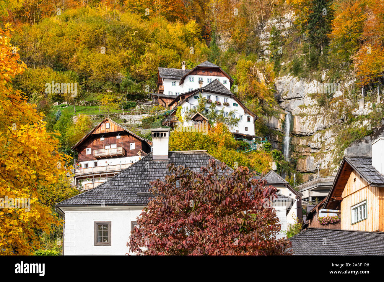 Hillside village buildings with fall foliage color in Hallstatt ...