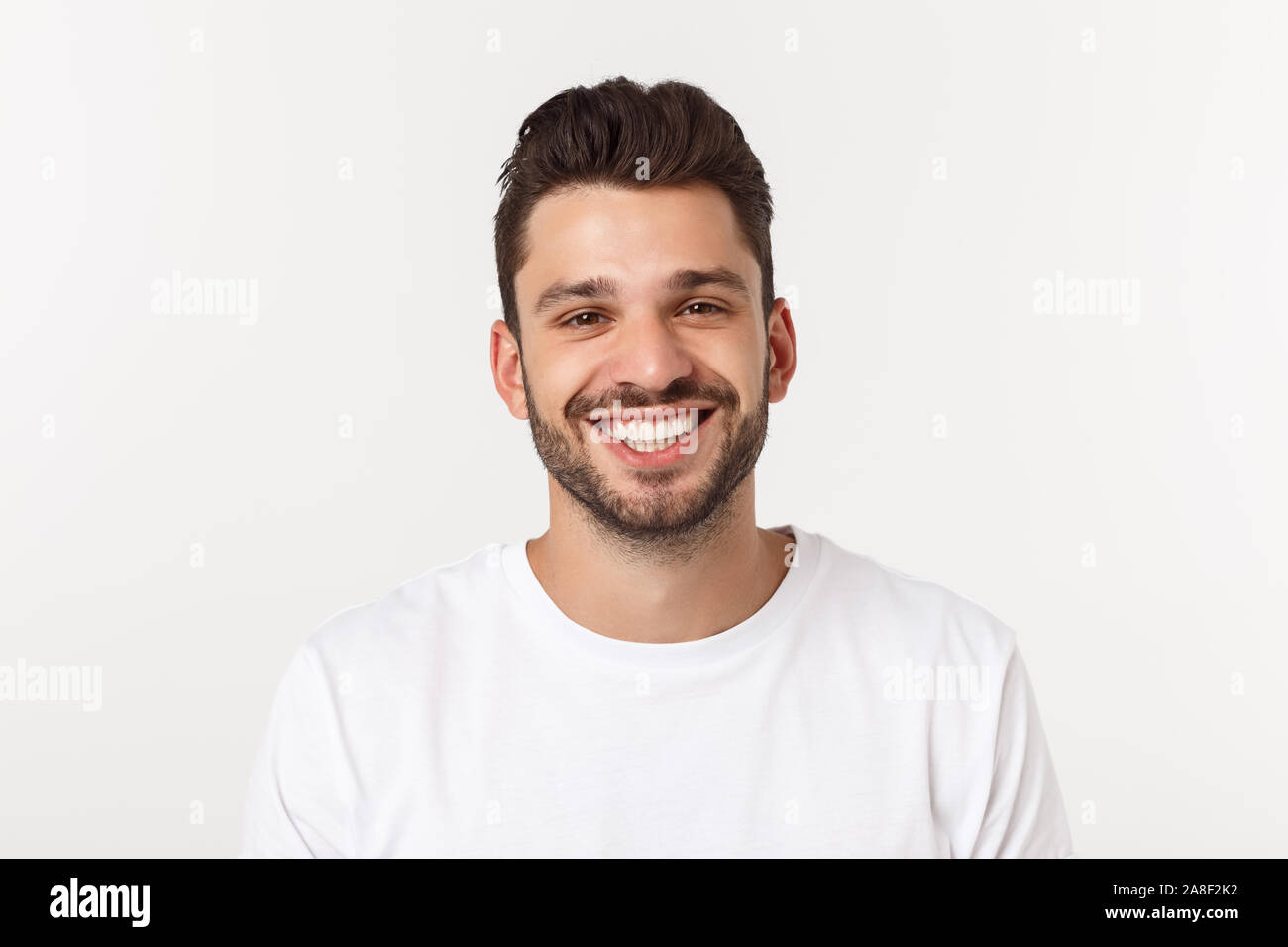 Portrait of a handsome young man smiling against yellow background ...