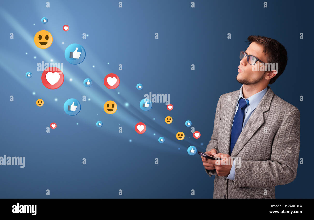 Young person using smartphone with flying social media icons around ...