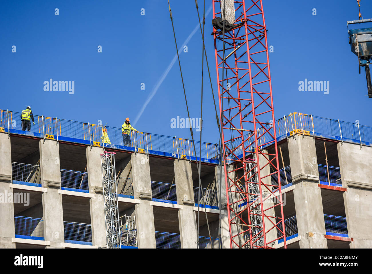 Workmen stand on the roof of a huge high rise Hilton Hotel development ...