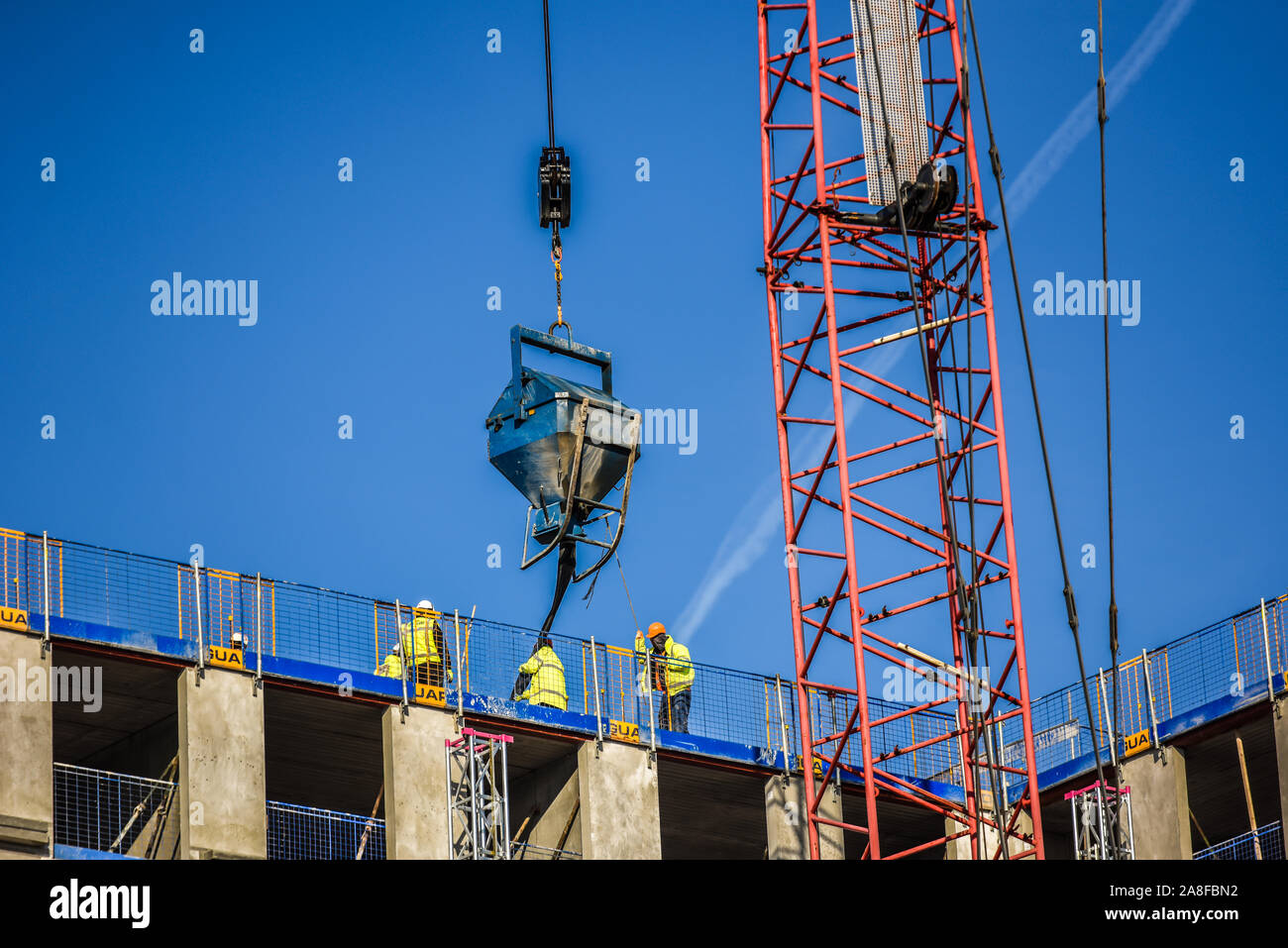 Workmen stand on the roof of a huge high rise Hilton Hotel development ...