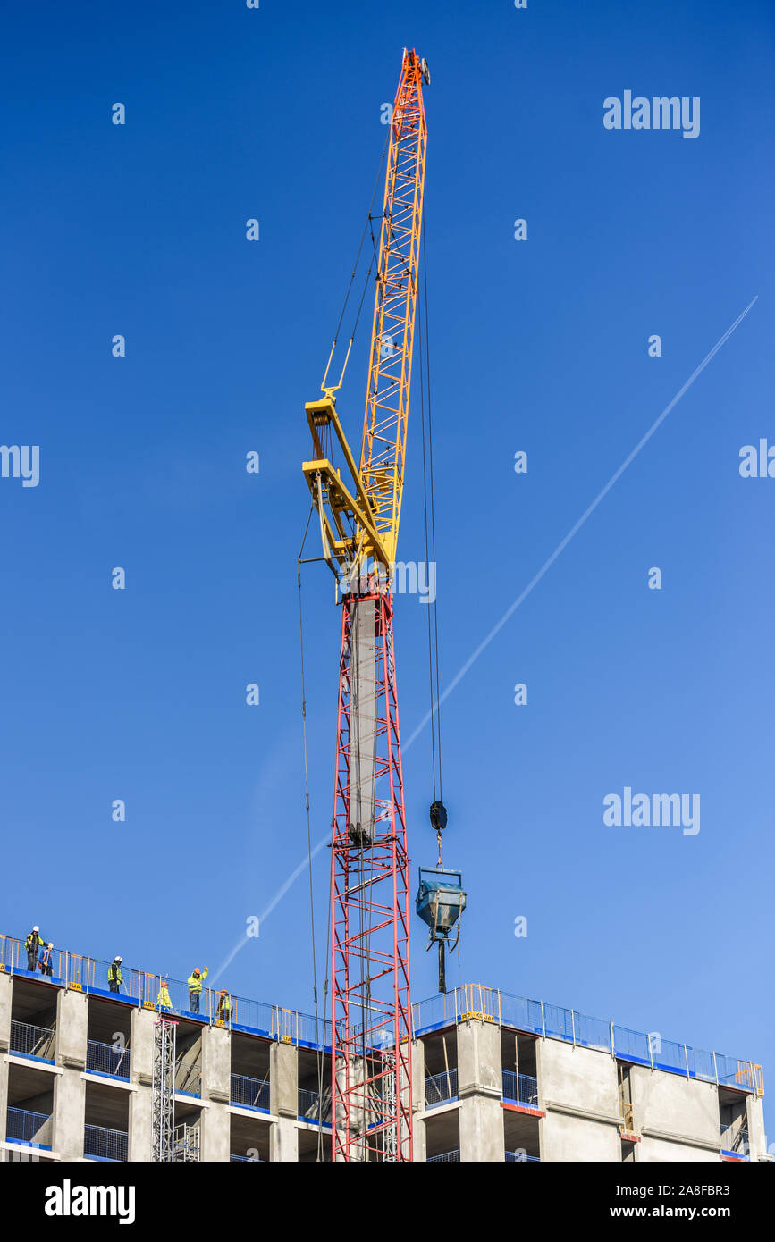 Workmen stand on the roof of a huge high rise Hilton Hotel development ...