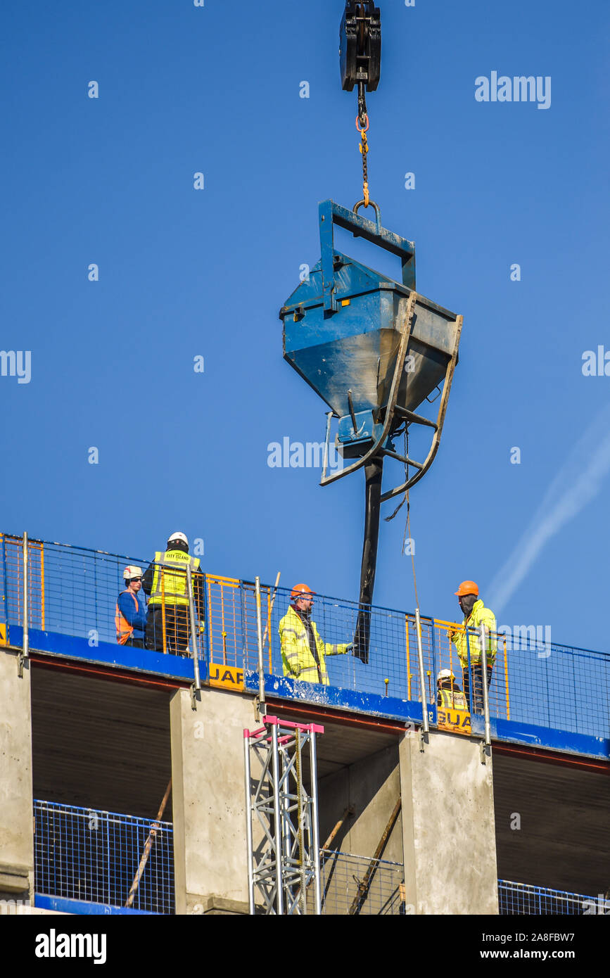 Workmen stand on the roof of a huge high rise Hilton Hotel development ...