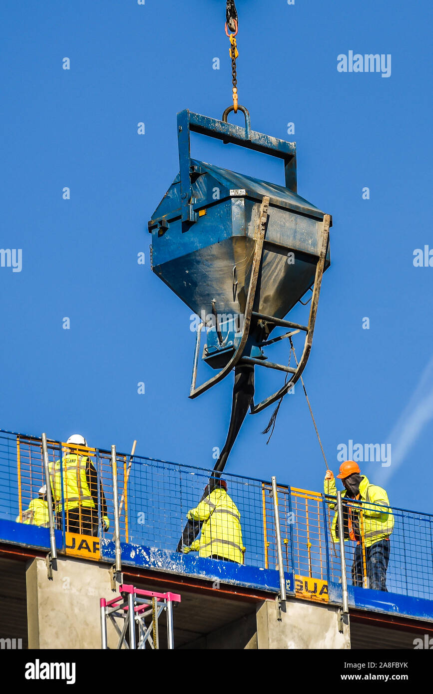 Workmen stand on the roof of a huge high rise Hilton Hotel development ...