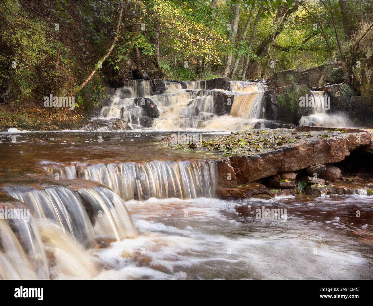 The waterfalls along the stream at Hareshaw Linn, Northumberland ...