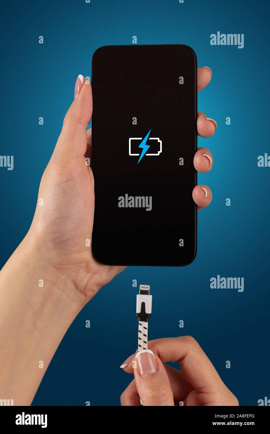 Elegant hand charging cellphone with low battery Stock Photo - Alamy
