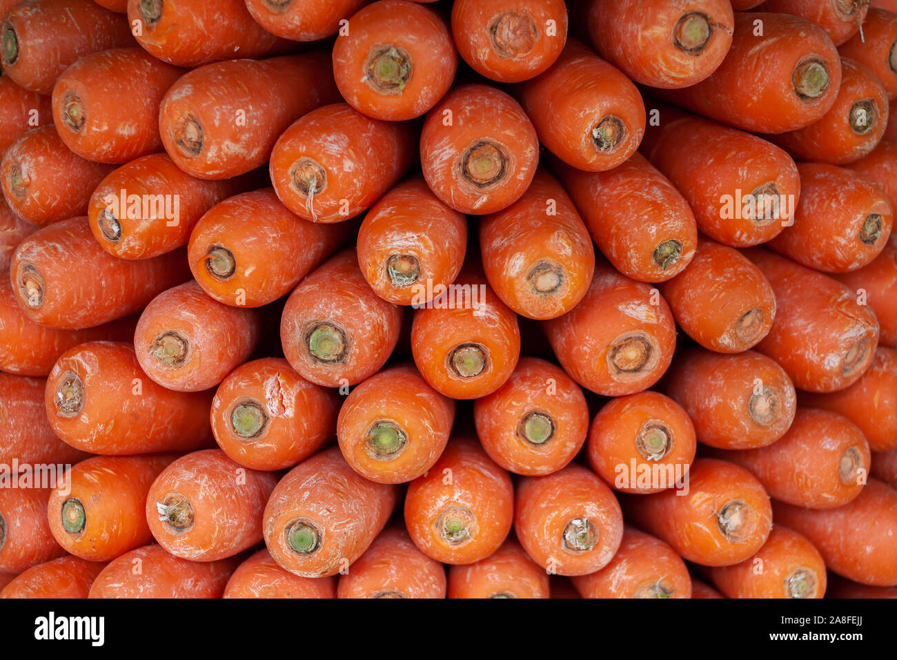 Carrots are nicely stacked and piled up on this little market stand in ...