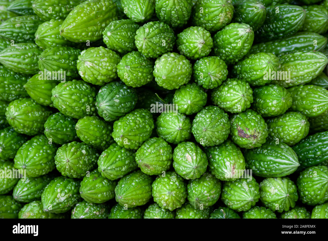 Cucumbers are nicely stacked and piled up on this little market stand ...