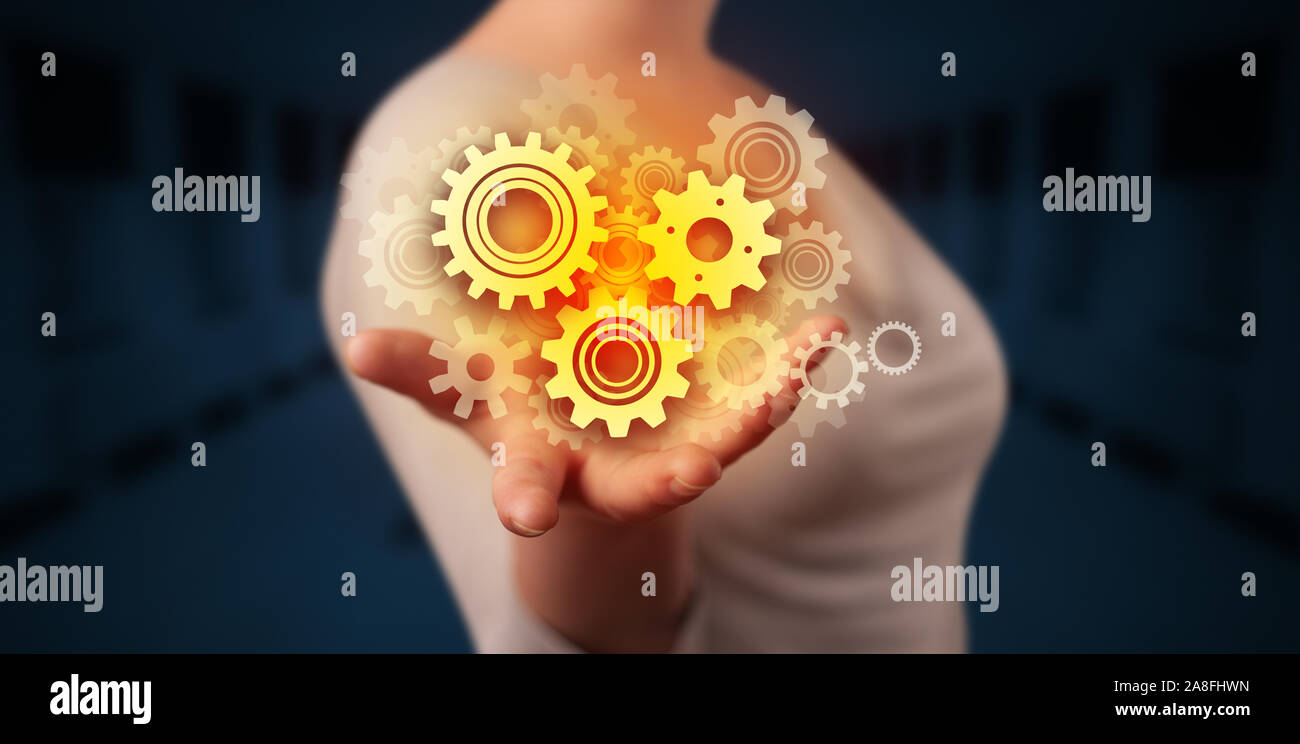 Hand holding gears in his hand Stock Photo - Alamy
