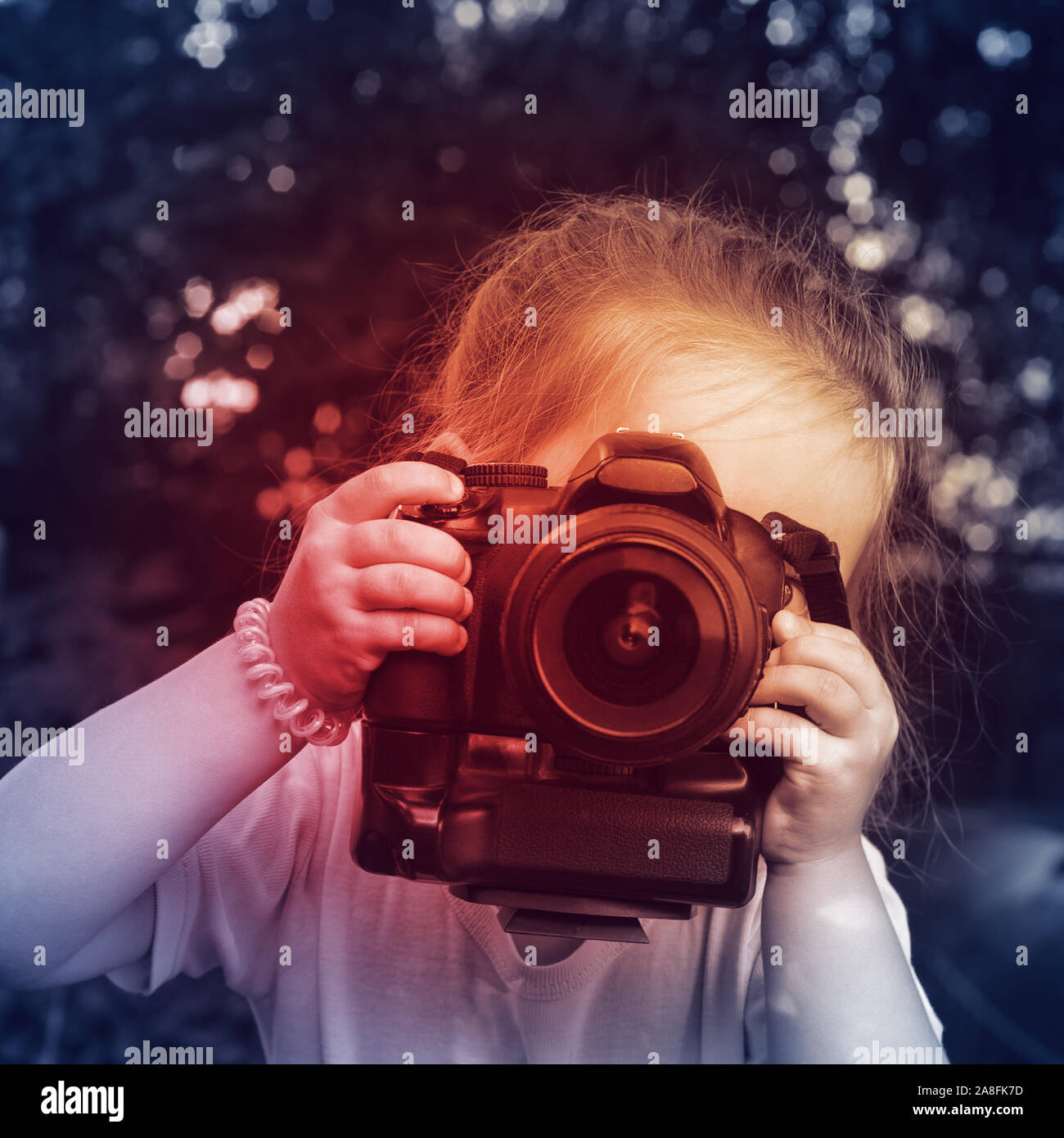 The little girl hid behind a large camera Stock Photo - Alamy