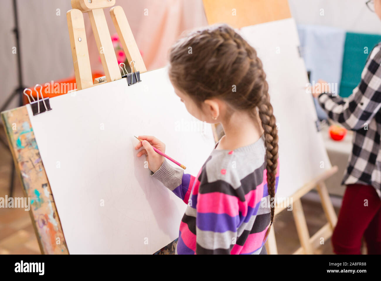 children draw on an easel in art school Stock Photo - Alamy