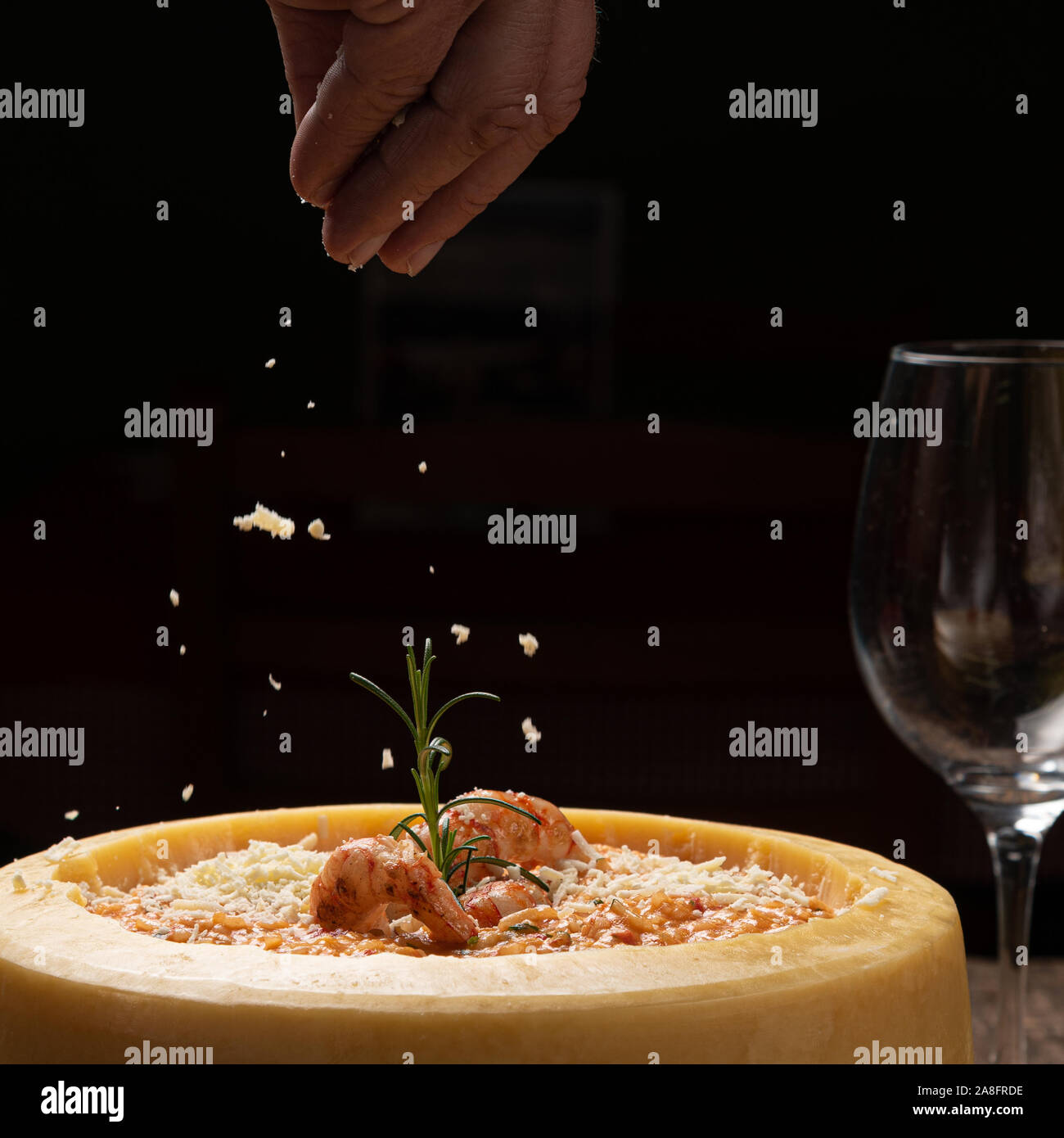 Italian shrimp risotto served inside a big Parmesan Cheese Wheel on a ...