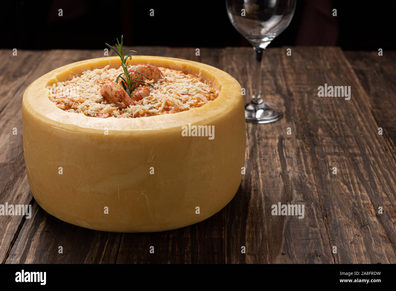 Italian shrimp risotto served inside a big Parmesan Cheese Wheel on a ...