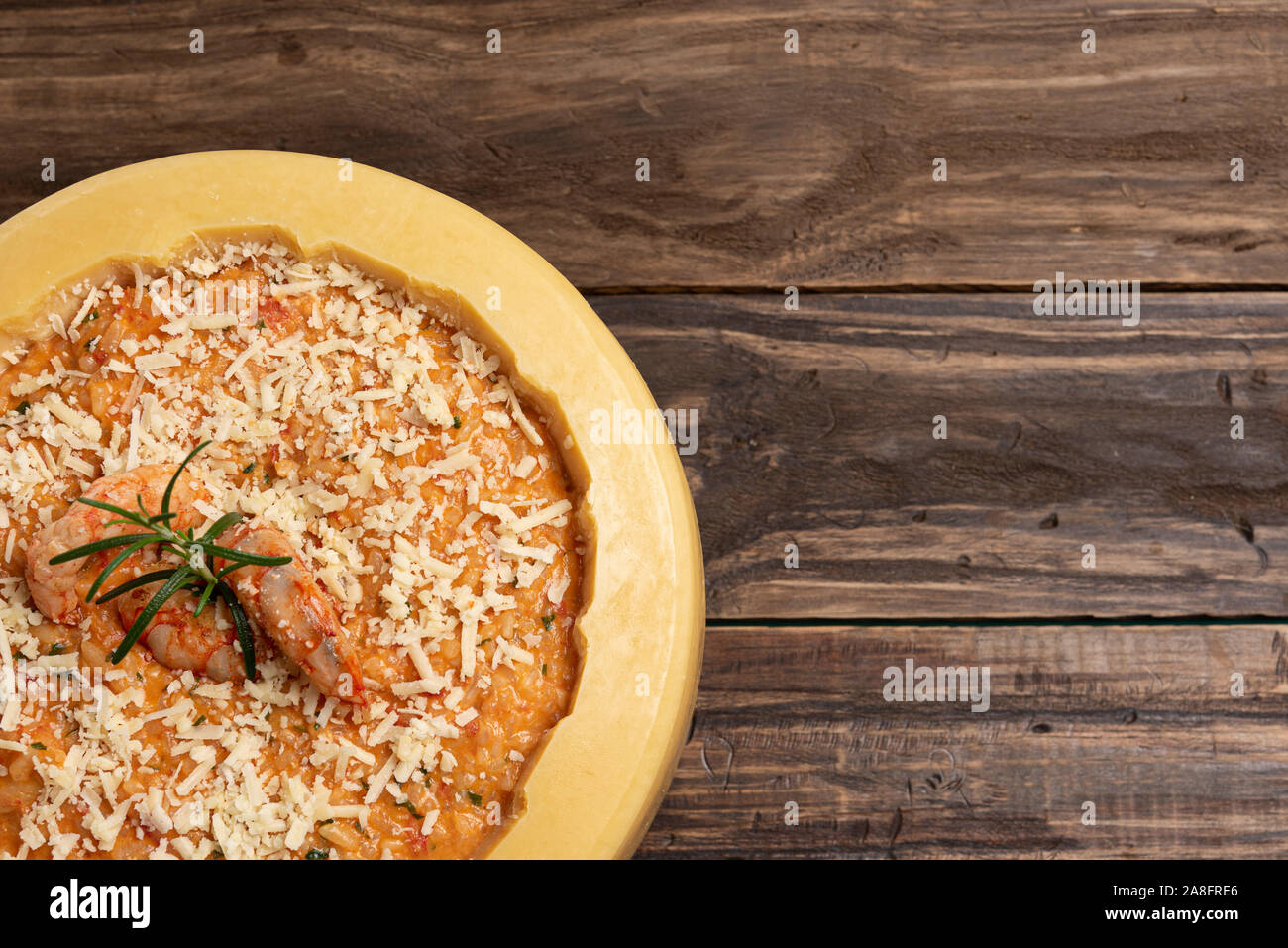 Italian shrimp risotto served inside a big Parmesan Cheese Wheel on a ...