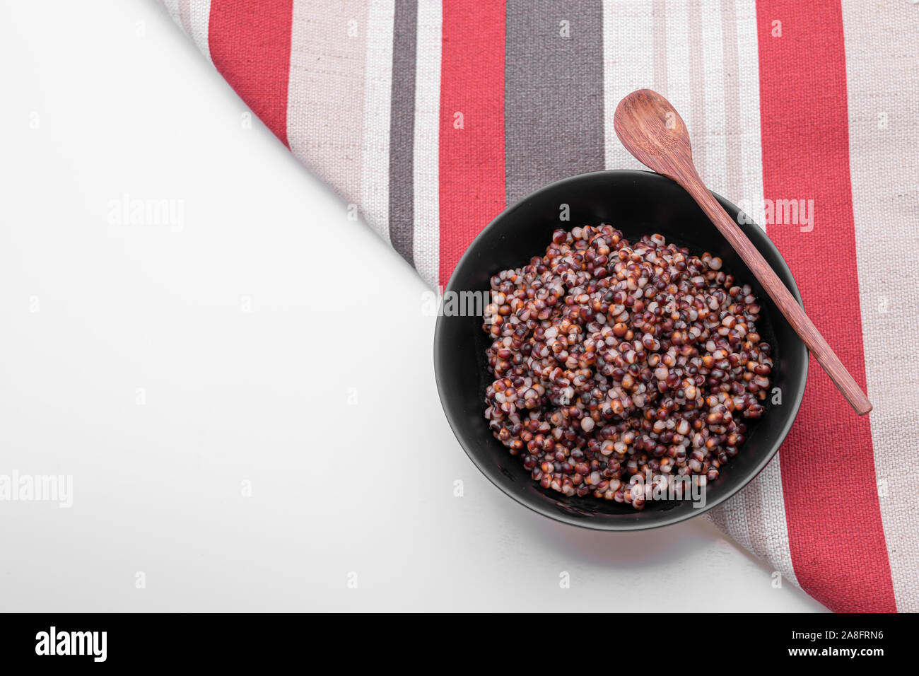 Cooked Sorghum (also known as sorgo) in a back bowl, isolated Stock ...