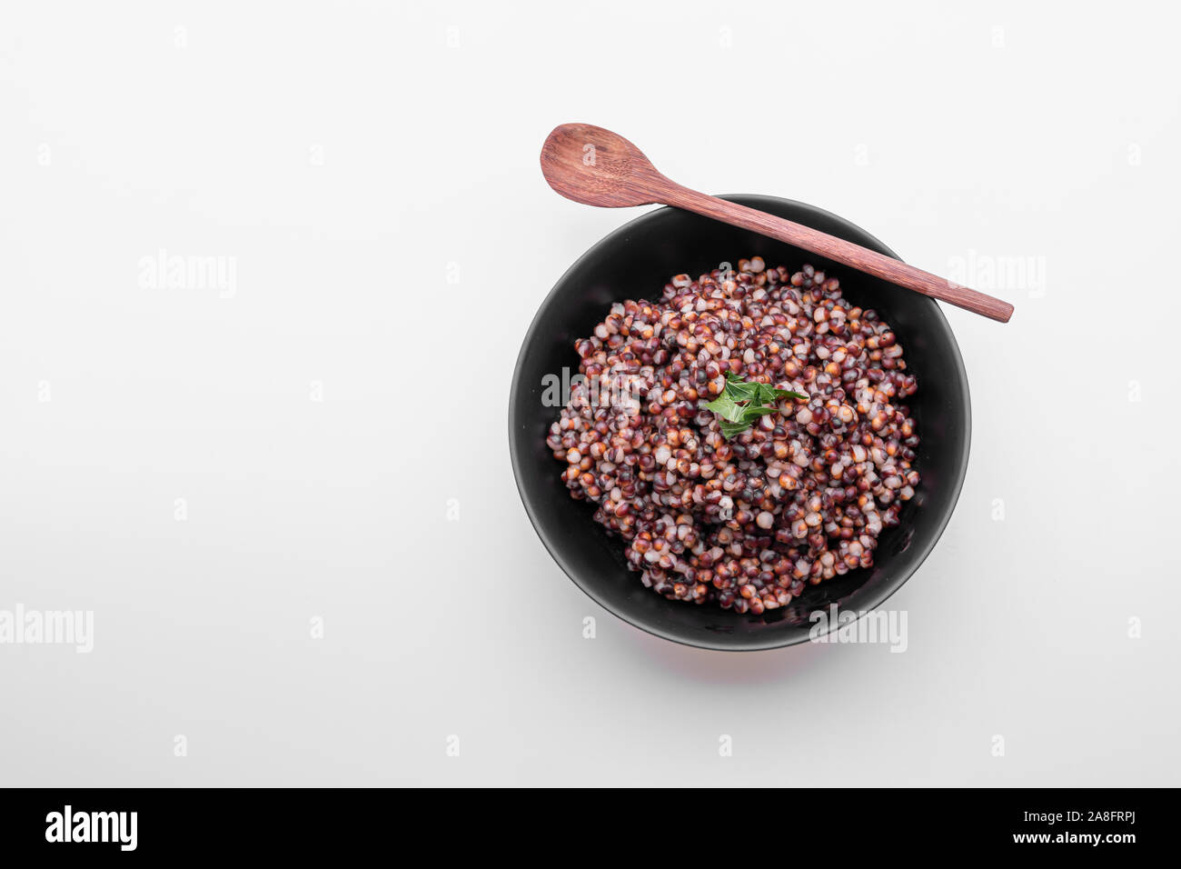 Cooked Sorghum (also known as sorgo) in a back bowl, isolated Stock ...