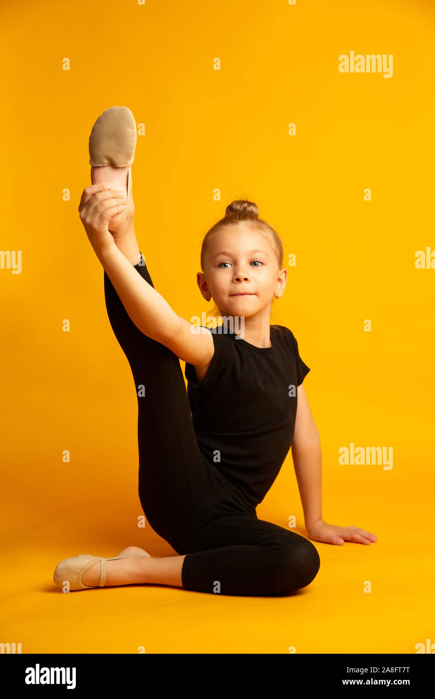 Little dancer in leotard stretching legs during workout Stock Photo - Alamy