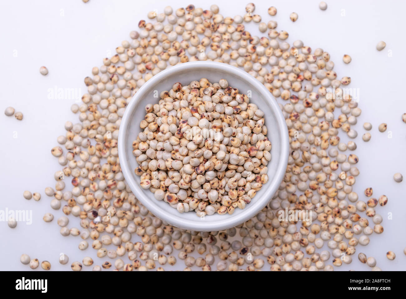 Uncooked raw Sorghum (also known as sorgo) in a white bowl, isolated on ...