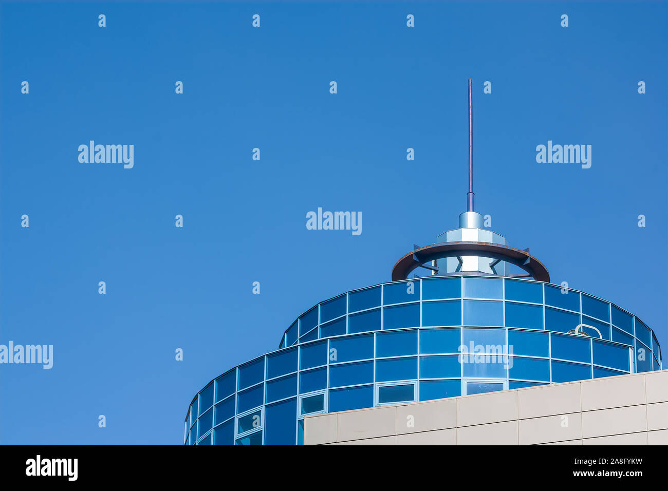 Fragment of the top of a modern high-rise building with a spire against ...