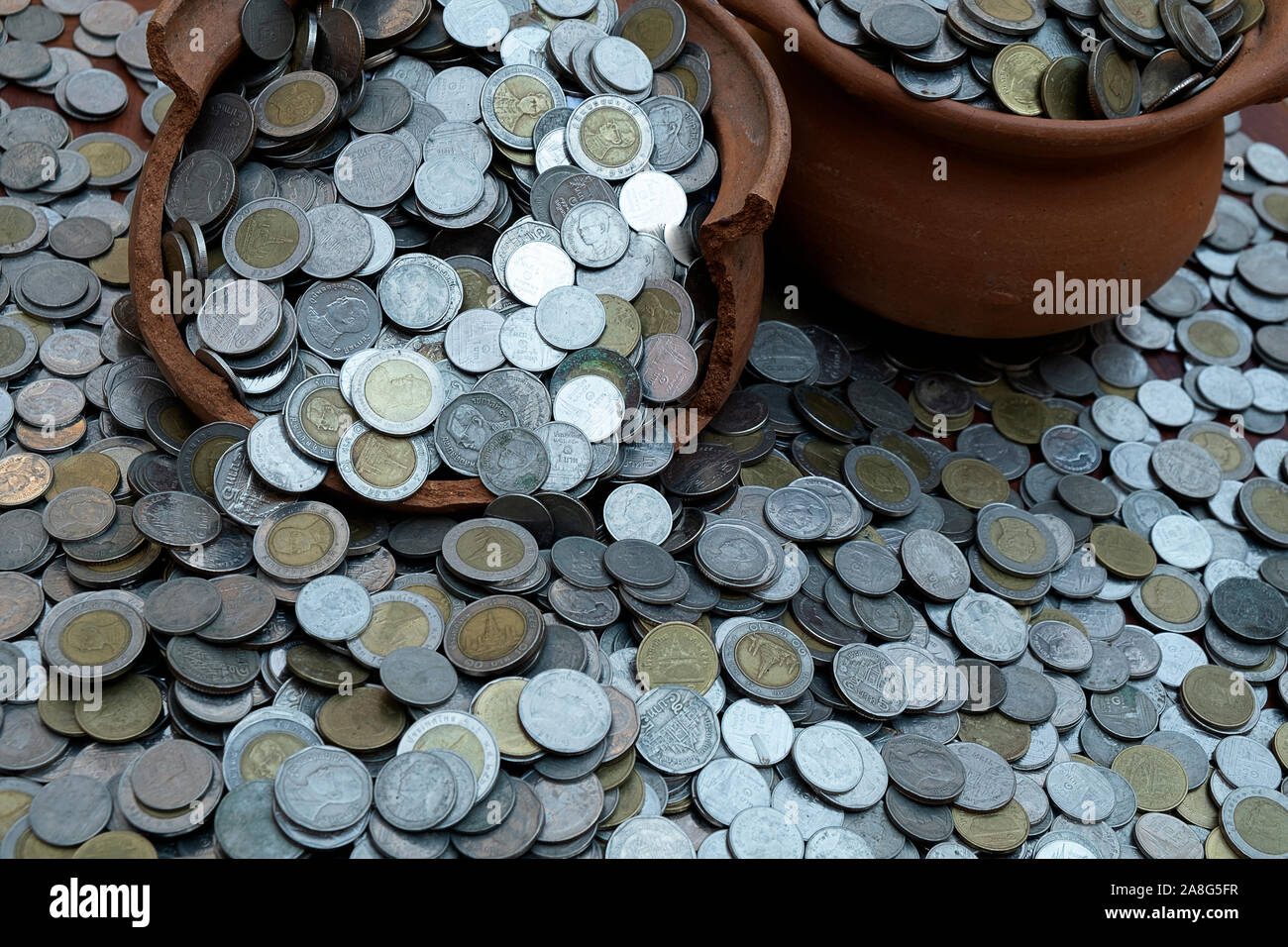 Coins in broken jar from on pile lots coin with blurred background ...