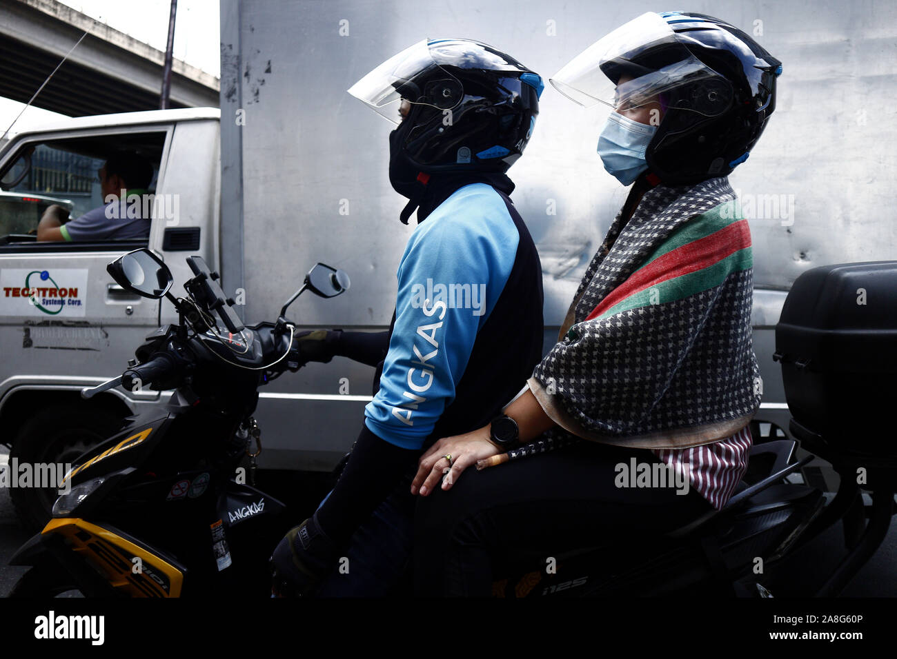 PASIG CITY, PHILIPPINES – NOVEMBER 4, 2019: Motorcycle taxi driver and ...