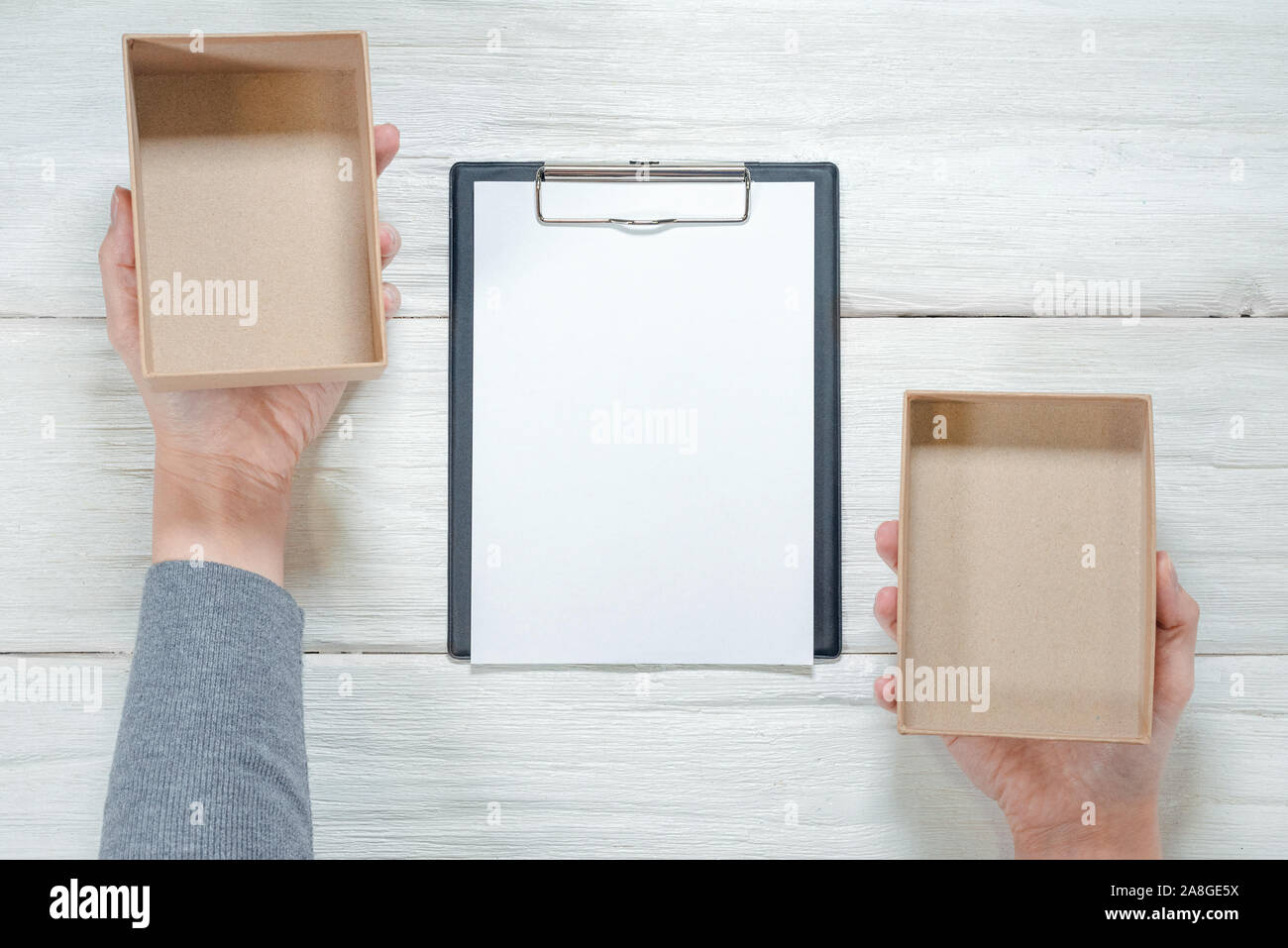 Cardboard box a postal parcel in female hands and blank document with ...