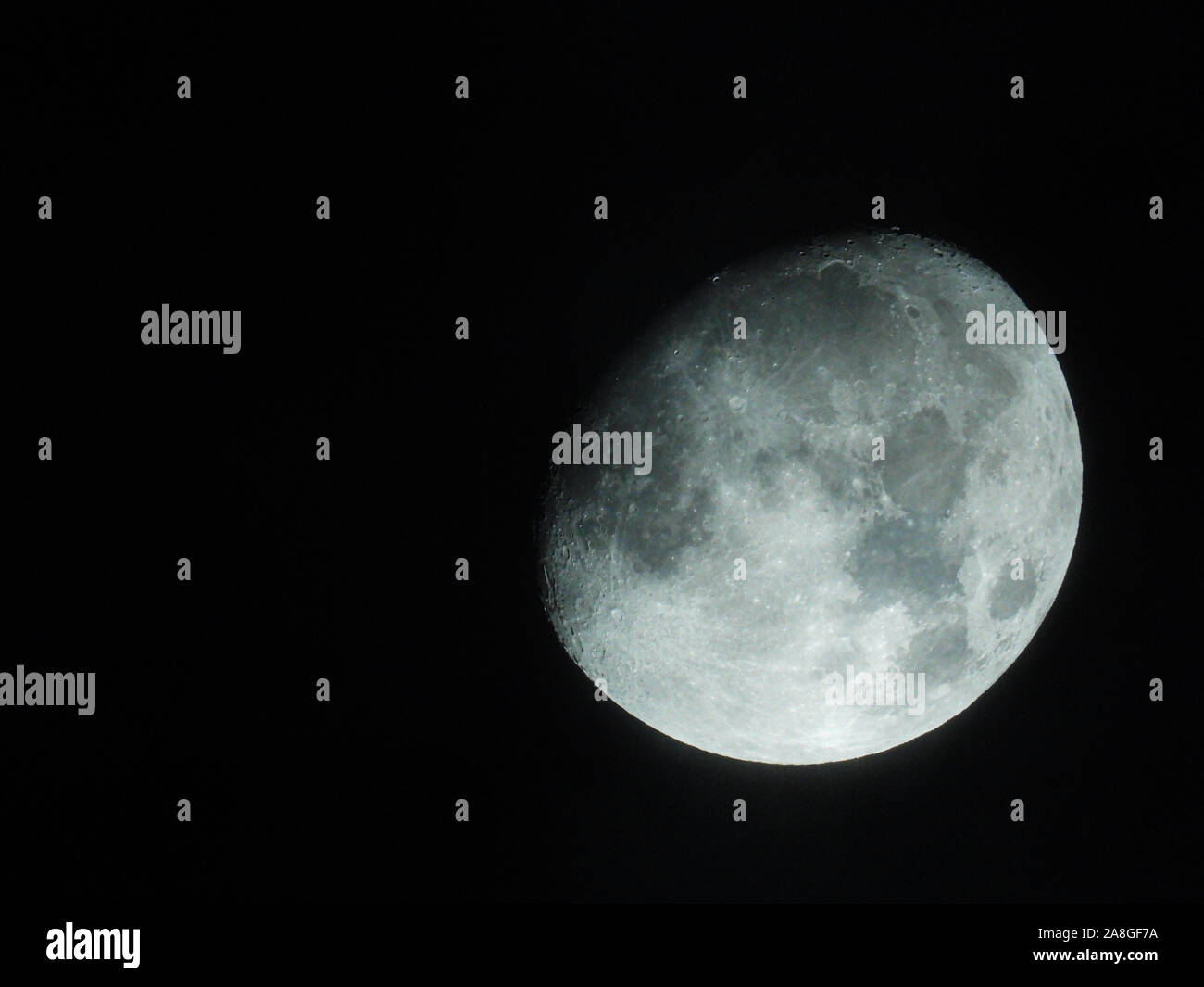 a bright three-quarter moon stands in the night sky Stock Photo - Alamy