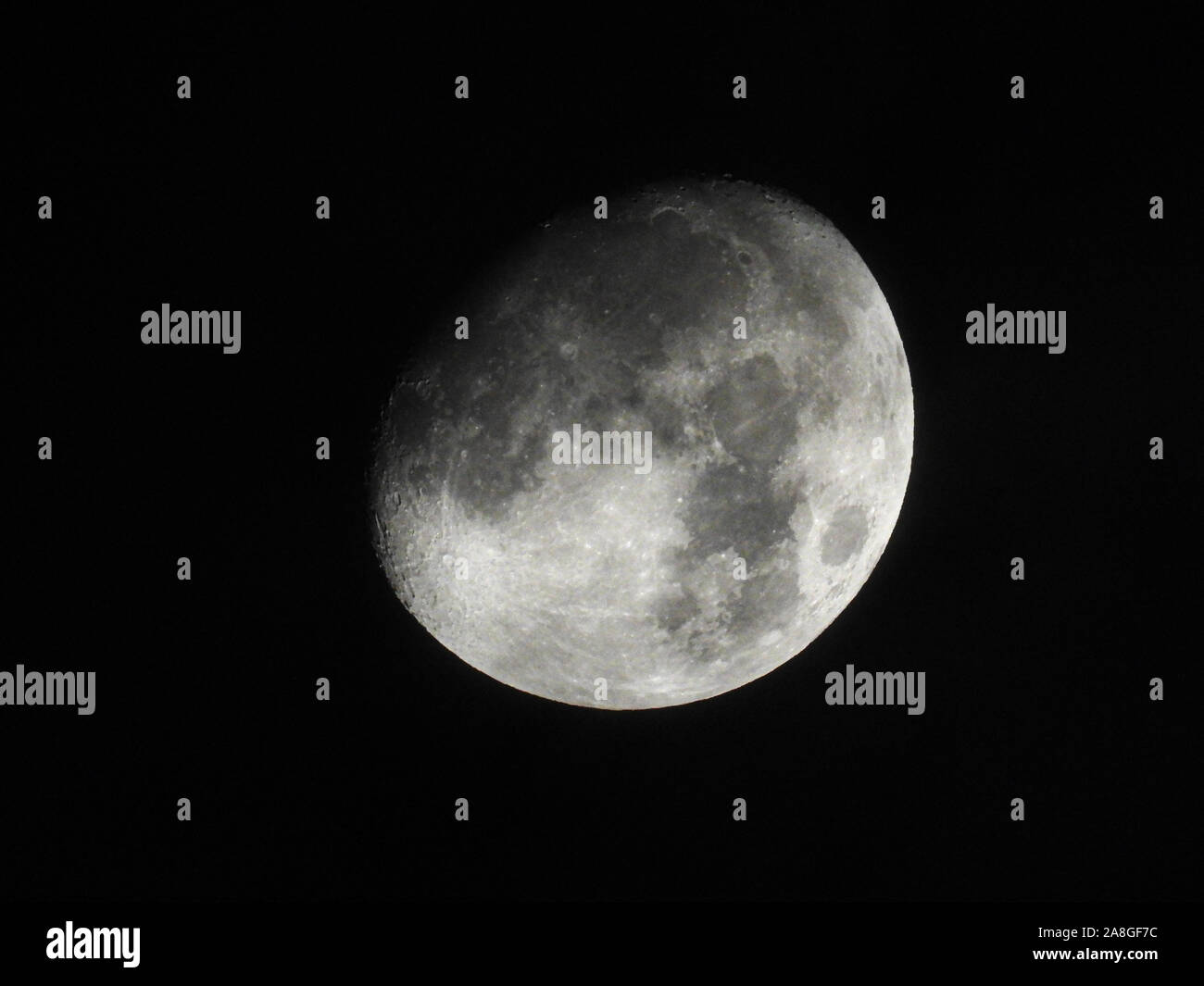 a bright three-quarter moon stands in the night sky Stock Photo - Alamy