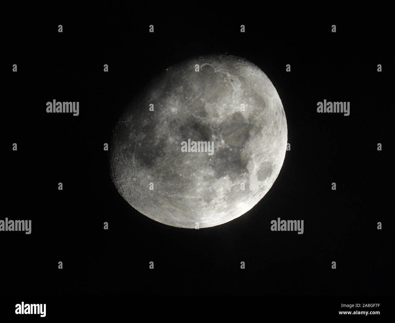 a bright three-quarter moon stands in the night sky Stock Photo - Alamy