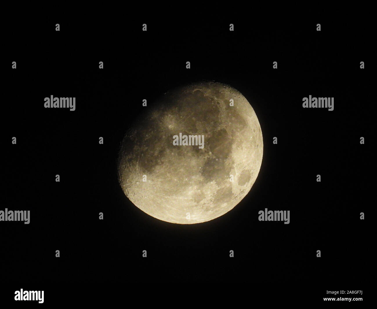 a bright three-quarter moon stands in the night sky Stock Photo - Alamy