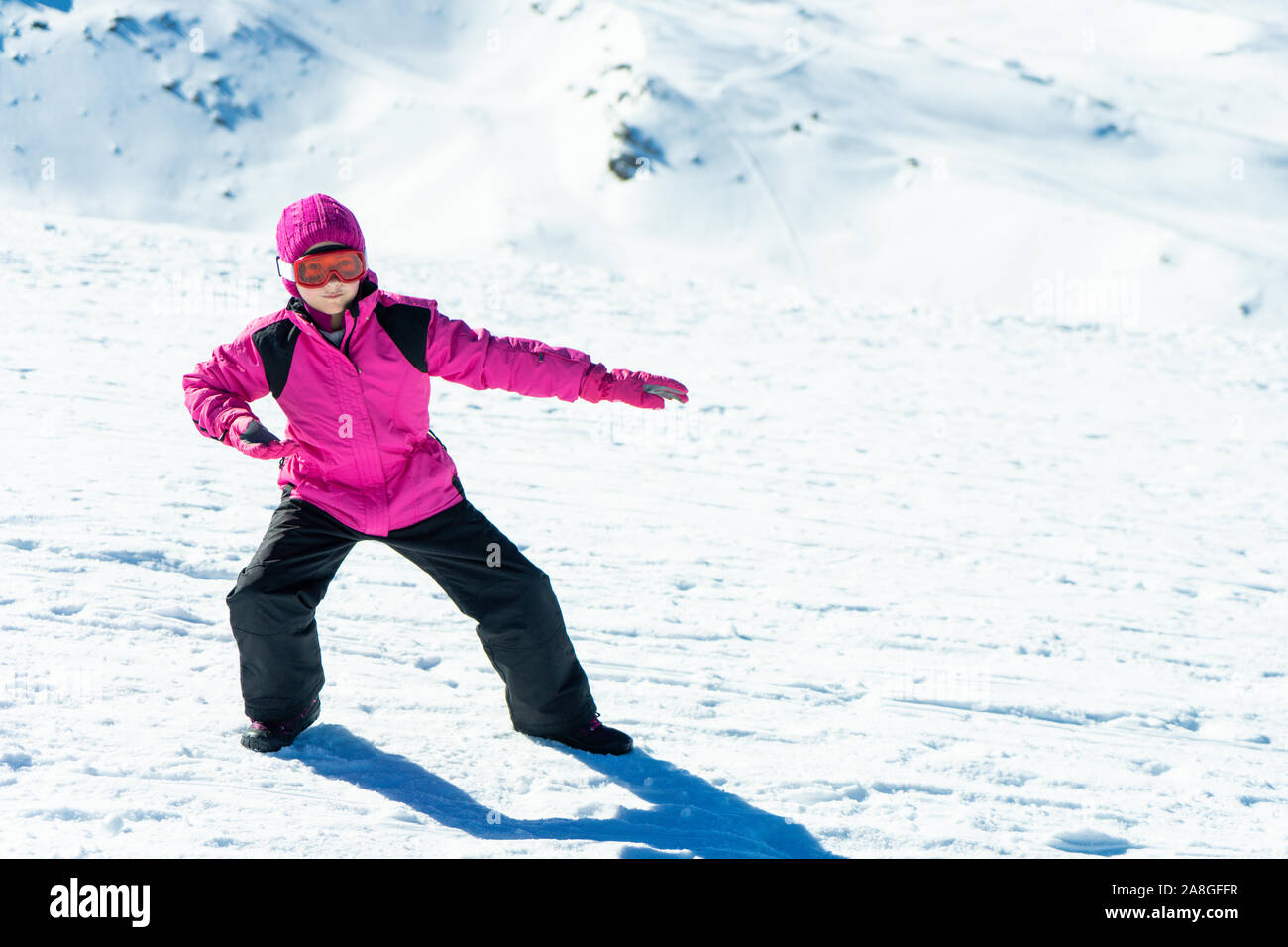 Little girl playing snowboard trainer on snow Stock Photo - Alamy