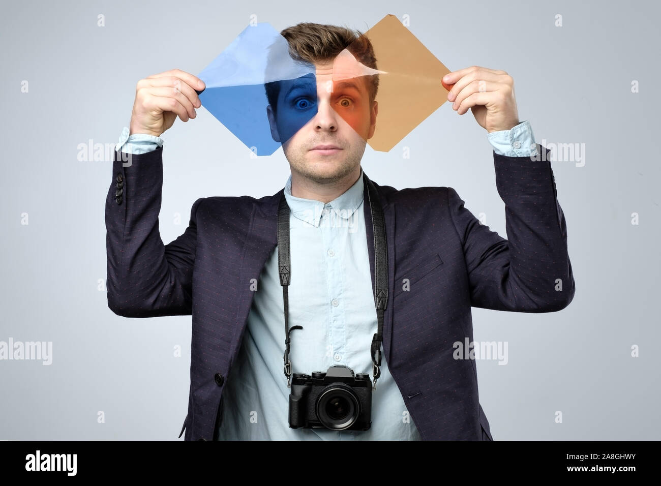 Young man photographer with dslr camera holding color filters red and ...